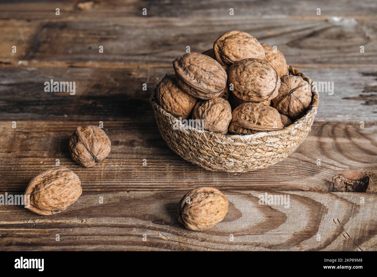 Close-up, whole walnuts in a wicker bowl on a wooden background Stock ...