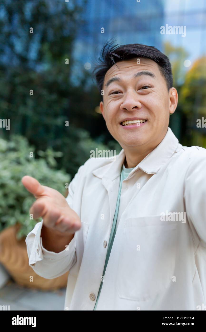 Asian programmer talking on video call using app on phone, view camera ...