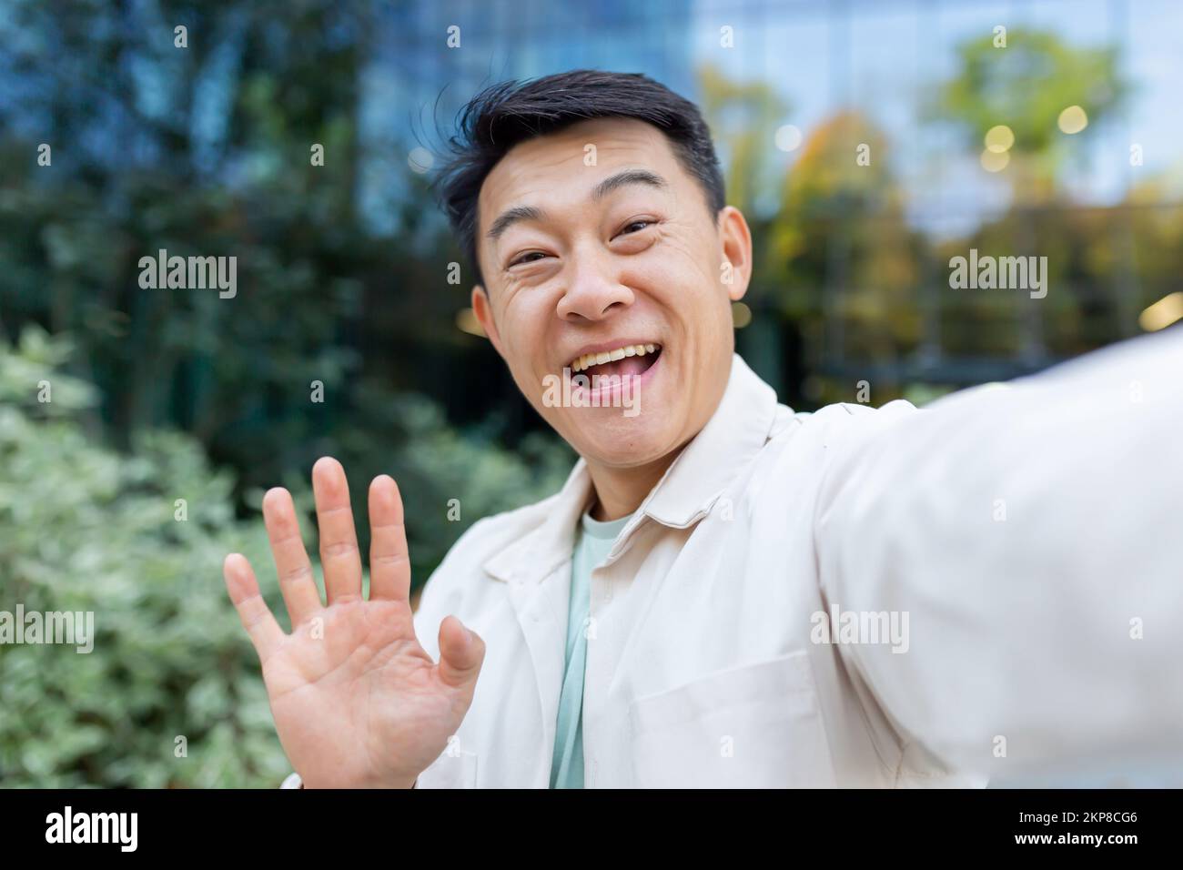 Asian programmer talking on video call using app on phone, view camera ...