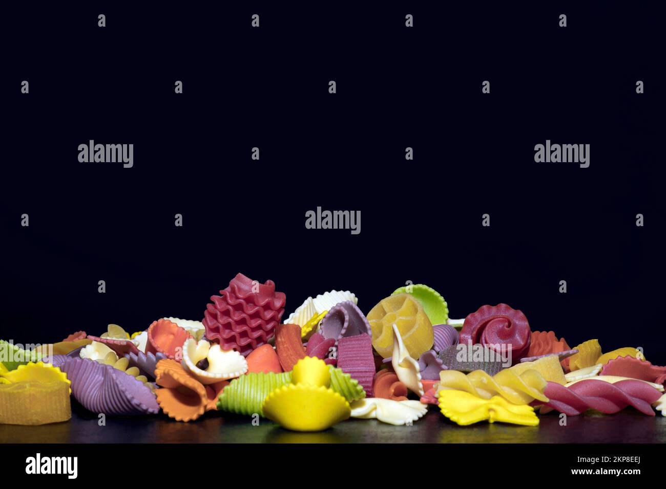 Colourful pasta in different shapes, food photography with a dark ...