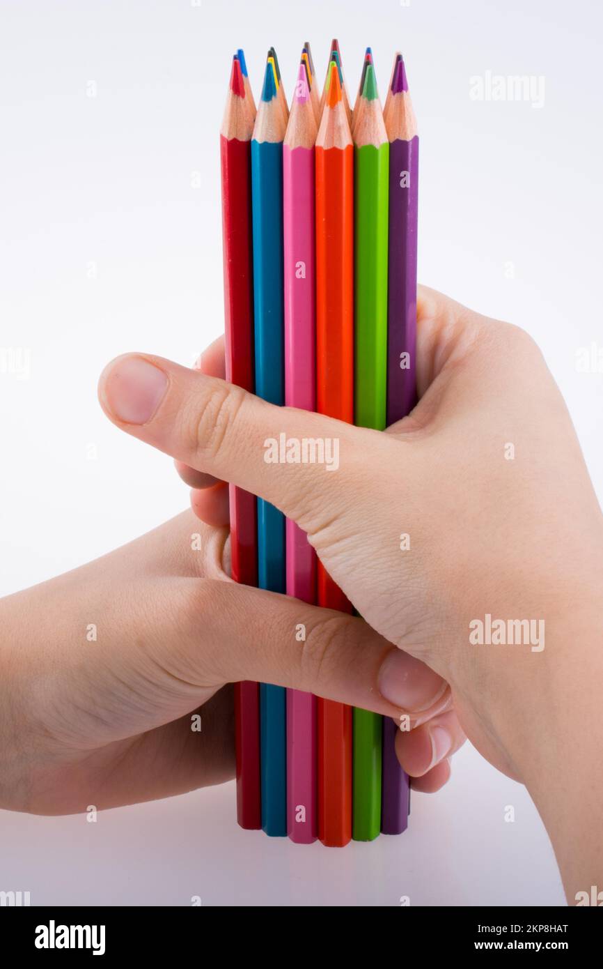 Hand holding color pencils on a white background Stock Photo - Alamy