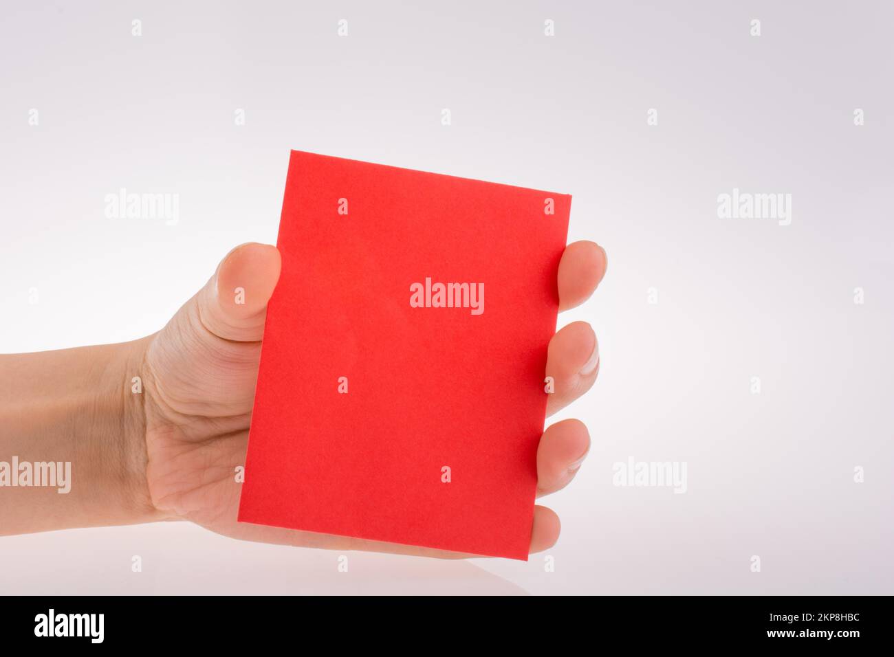 Hand holding a red note paper on white background Stock Photo - Alamy