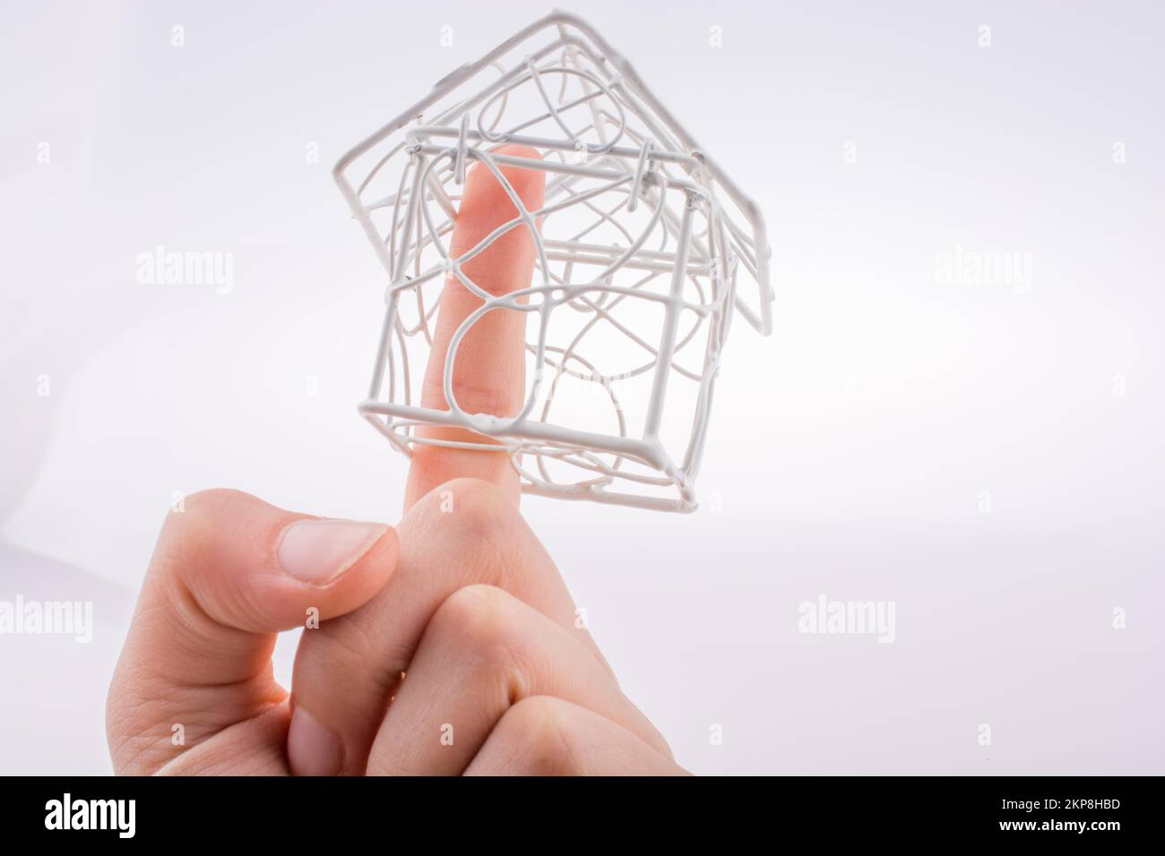 Little model house made of white metal wire in hand Stock Photo - Alamy
