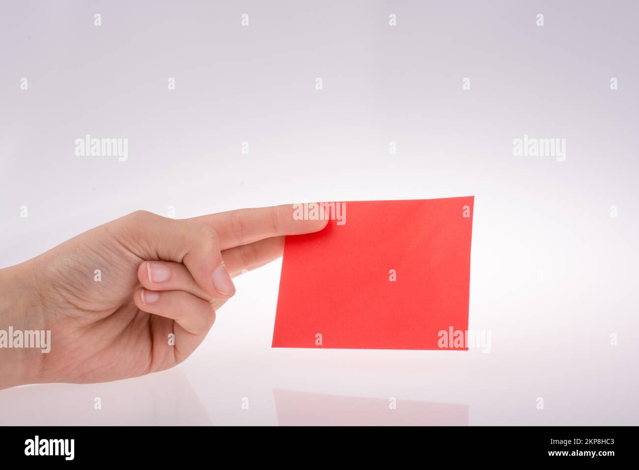Hand holding a red note paper on white background Stock Photo - Alamy