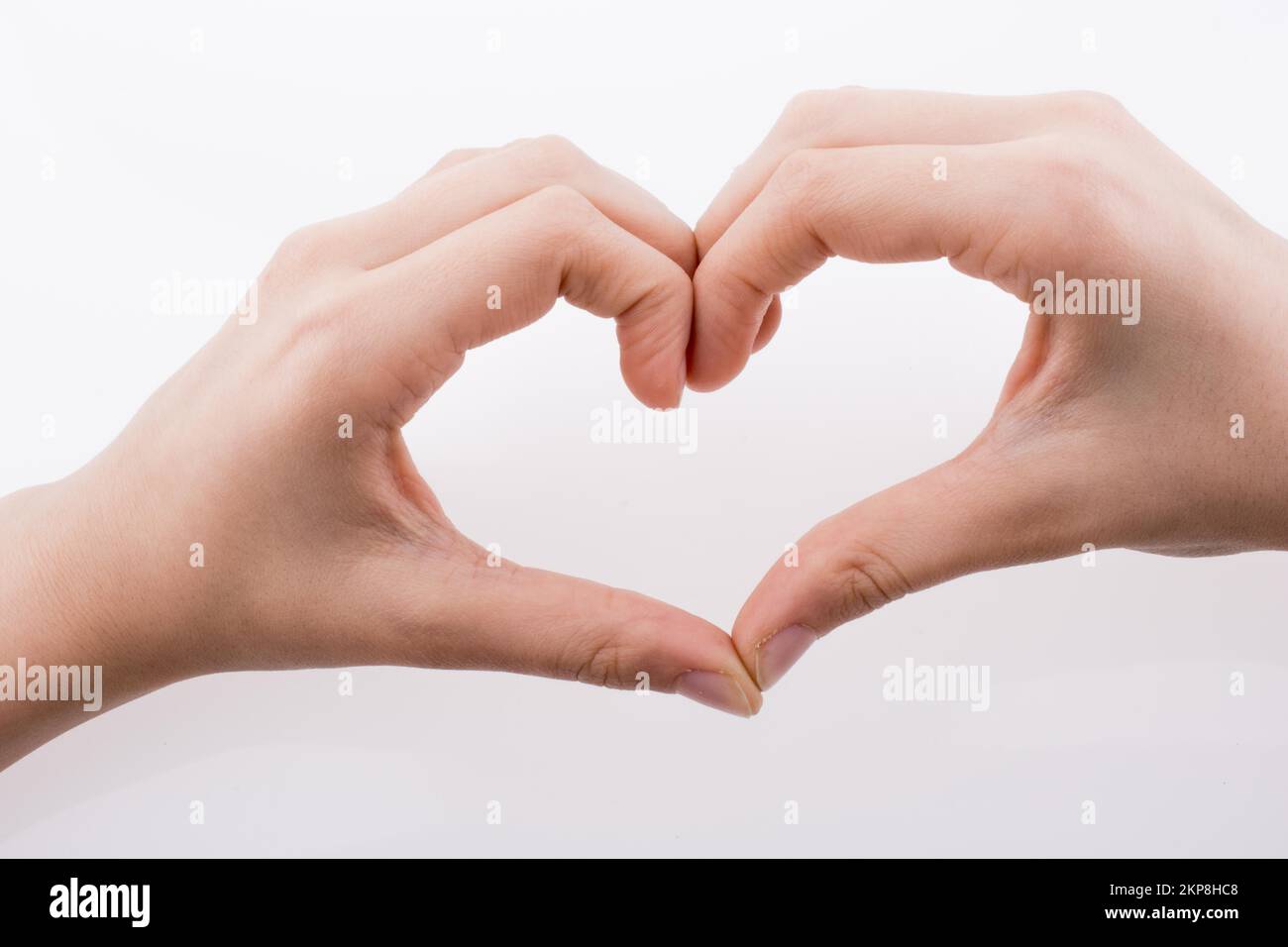 Hand making a heart shape on a white background Stock Photo - Alamy