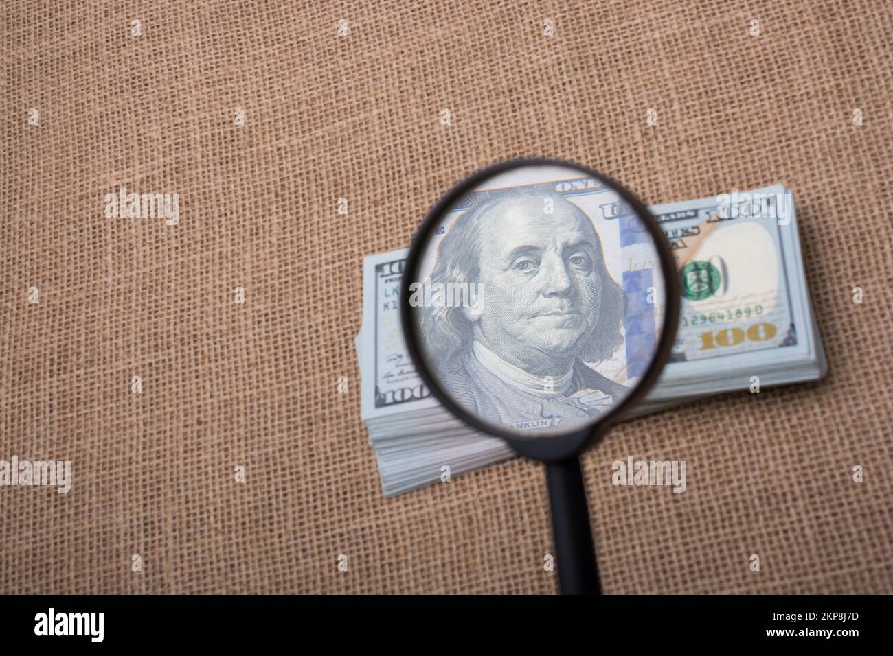 Magnifying glass over the banknote bundle of US dollar Stock Photo - Alamy