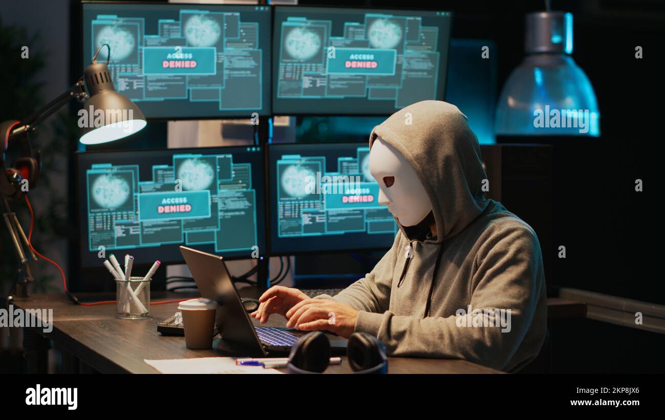 Masked hacking thief stealing information from database server, hacking computer hardware system ...