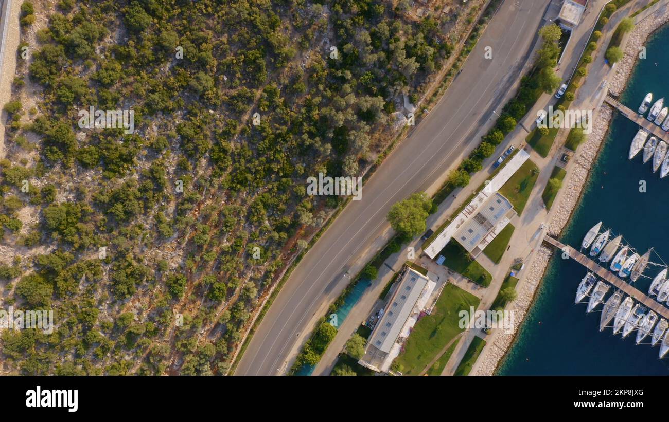 Aerial view of boats in harbor in sea bay. Mountain road along the sea ...