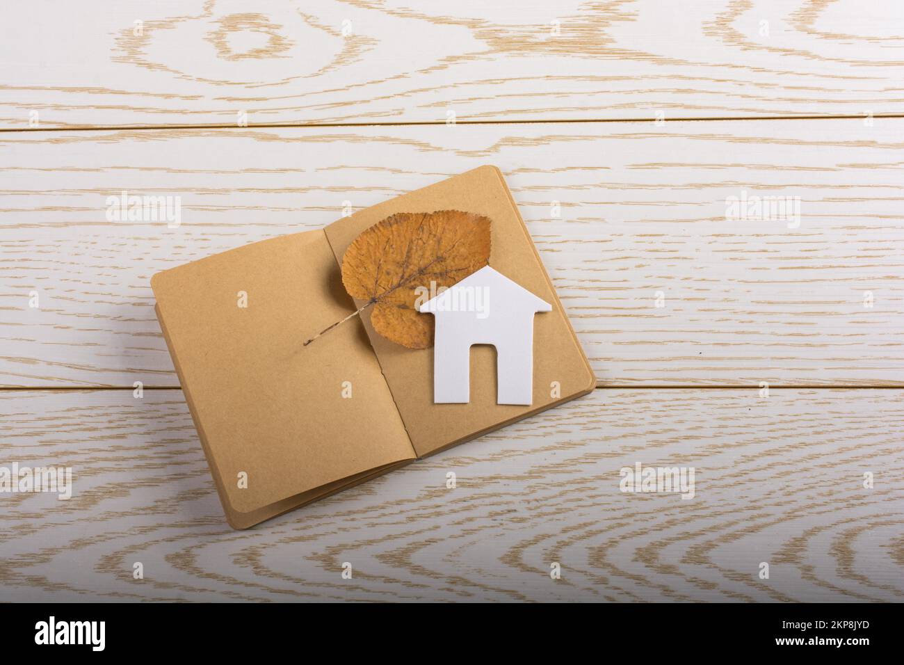 Little paper house on a notebook on parquet Stock Photo - Alamy