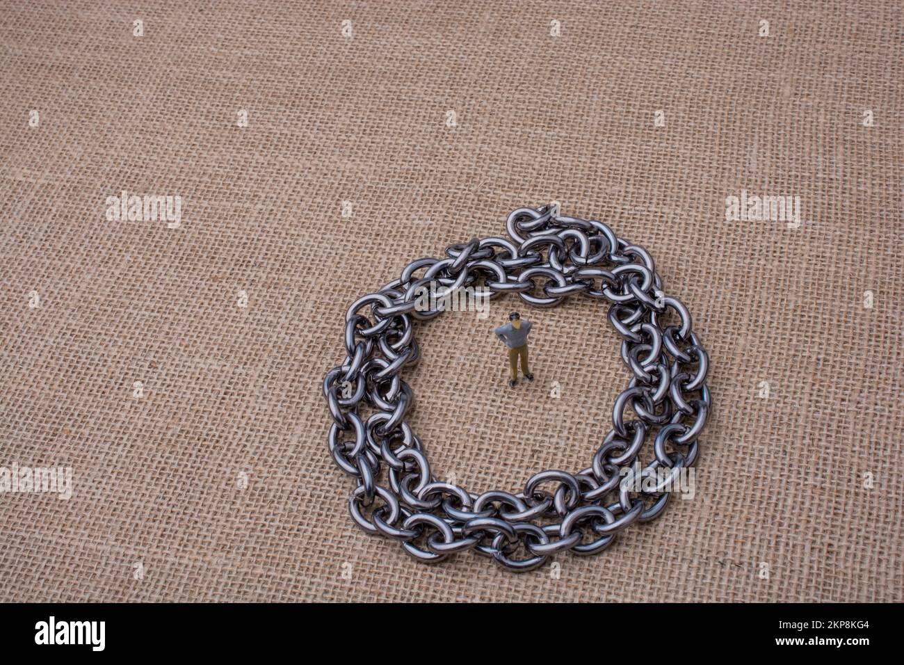 Man figurine trapped in the circle of a chain Stock Photo - Alamy