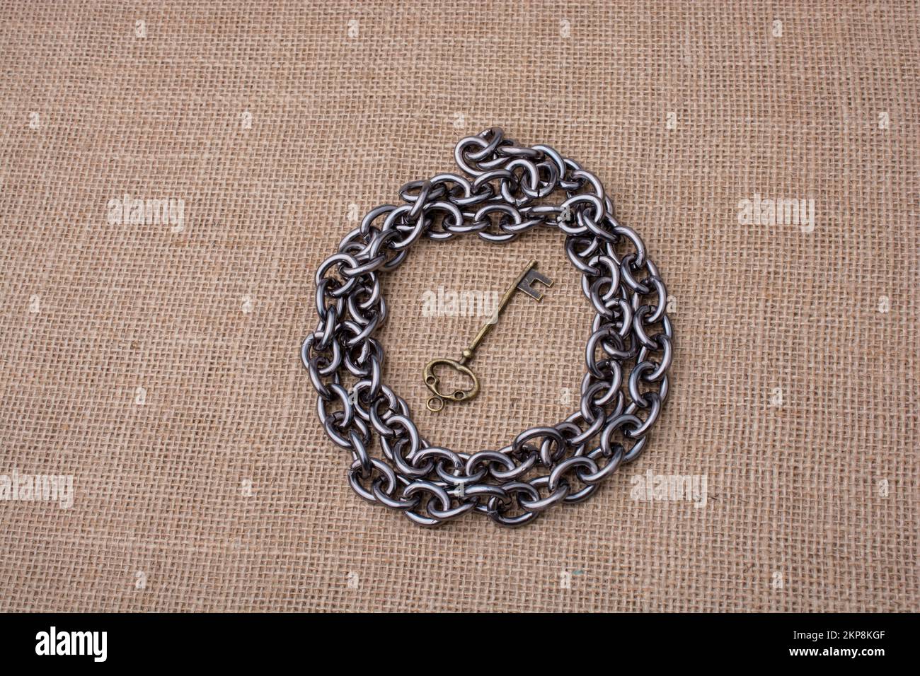 Metal chain around retro styled golden color key Stock Photo - Alamy