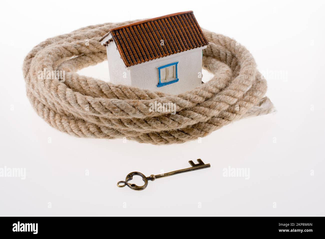Key and house surrounded by rope on a white background Stock Photo - Alamy