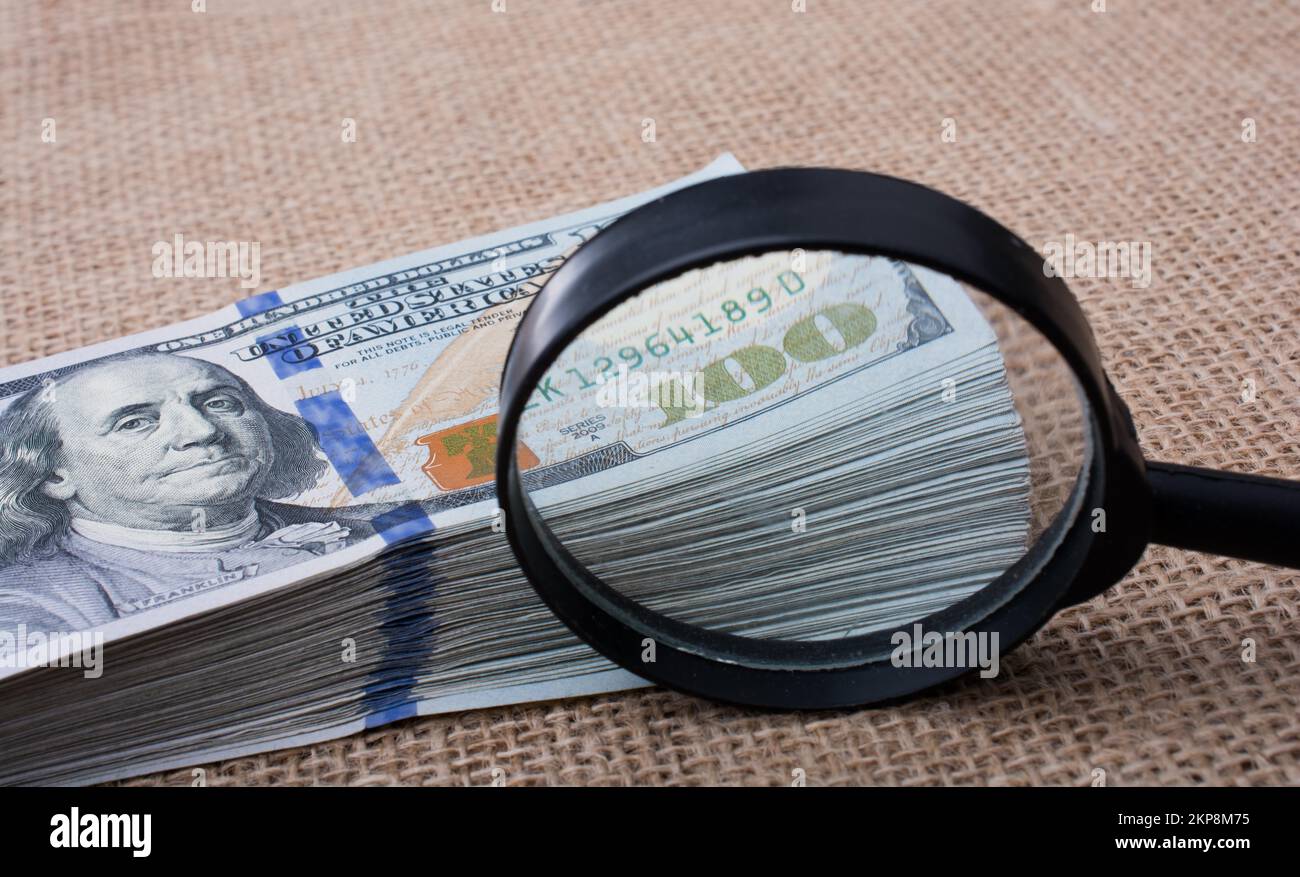 Magnifying glass over the banknote bundle of US dollar Stock Photo - Alamy