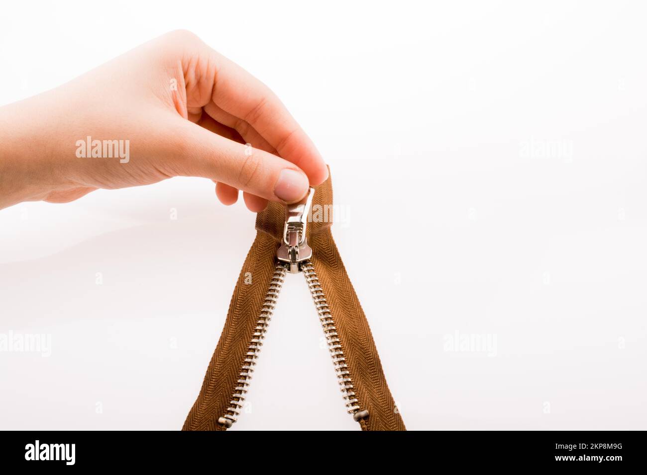 Hand holding color zipper on a white background Stock Photo - Alamy