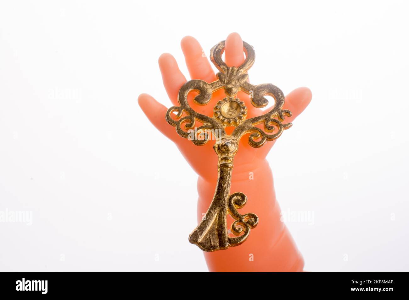 Doll holding a key on a white background Stock Photo - Alamy