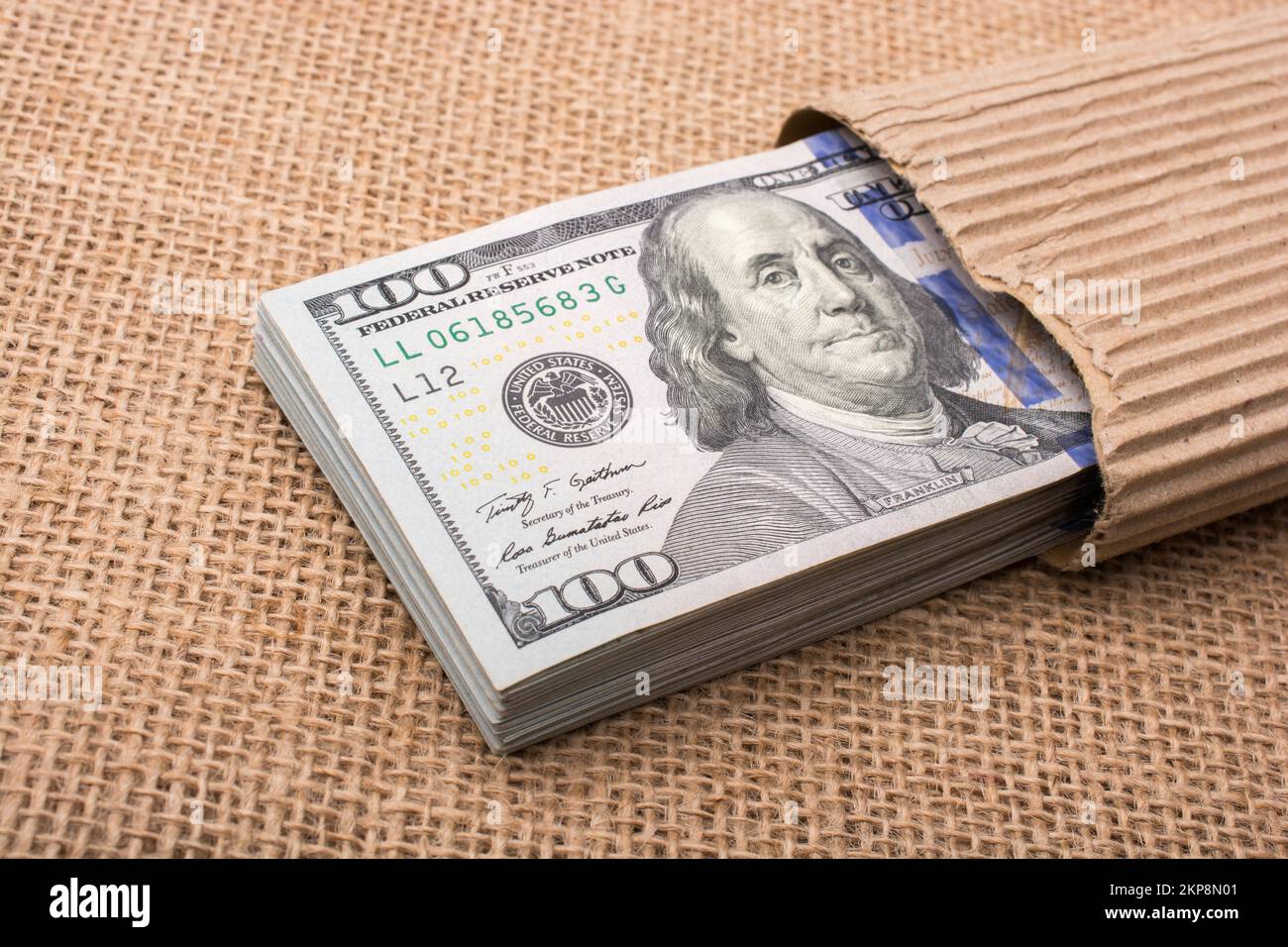 Banknote bundle of US dollar partly wrapped in cardboard Stock Photo ...
