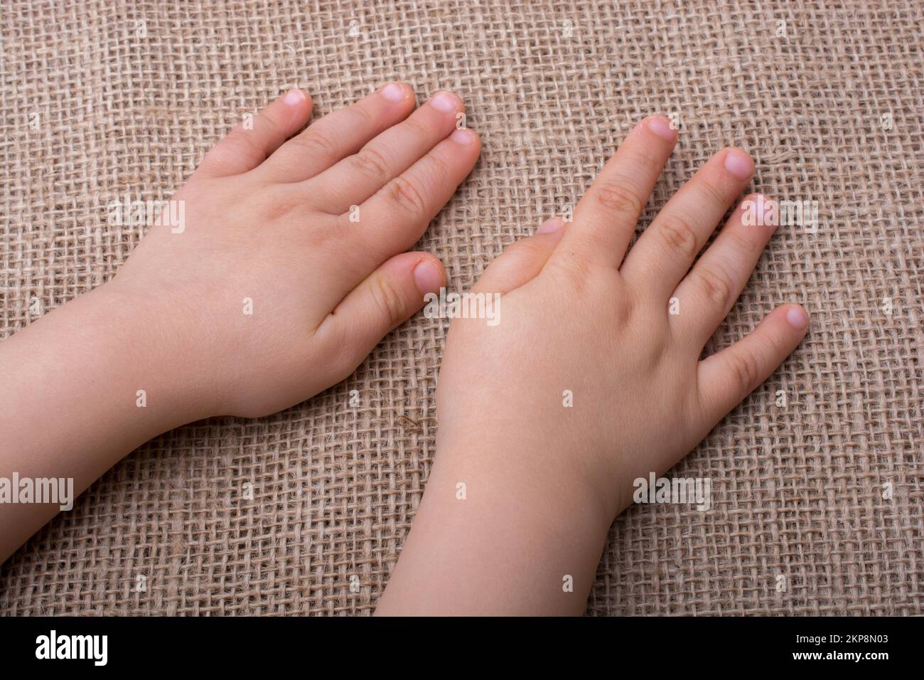 Toddler hand with canvas linen background Stock Photo - Alamy