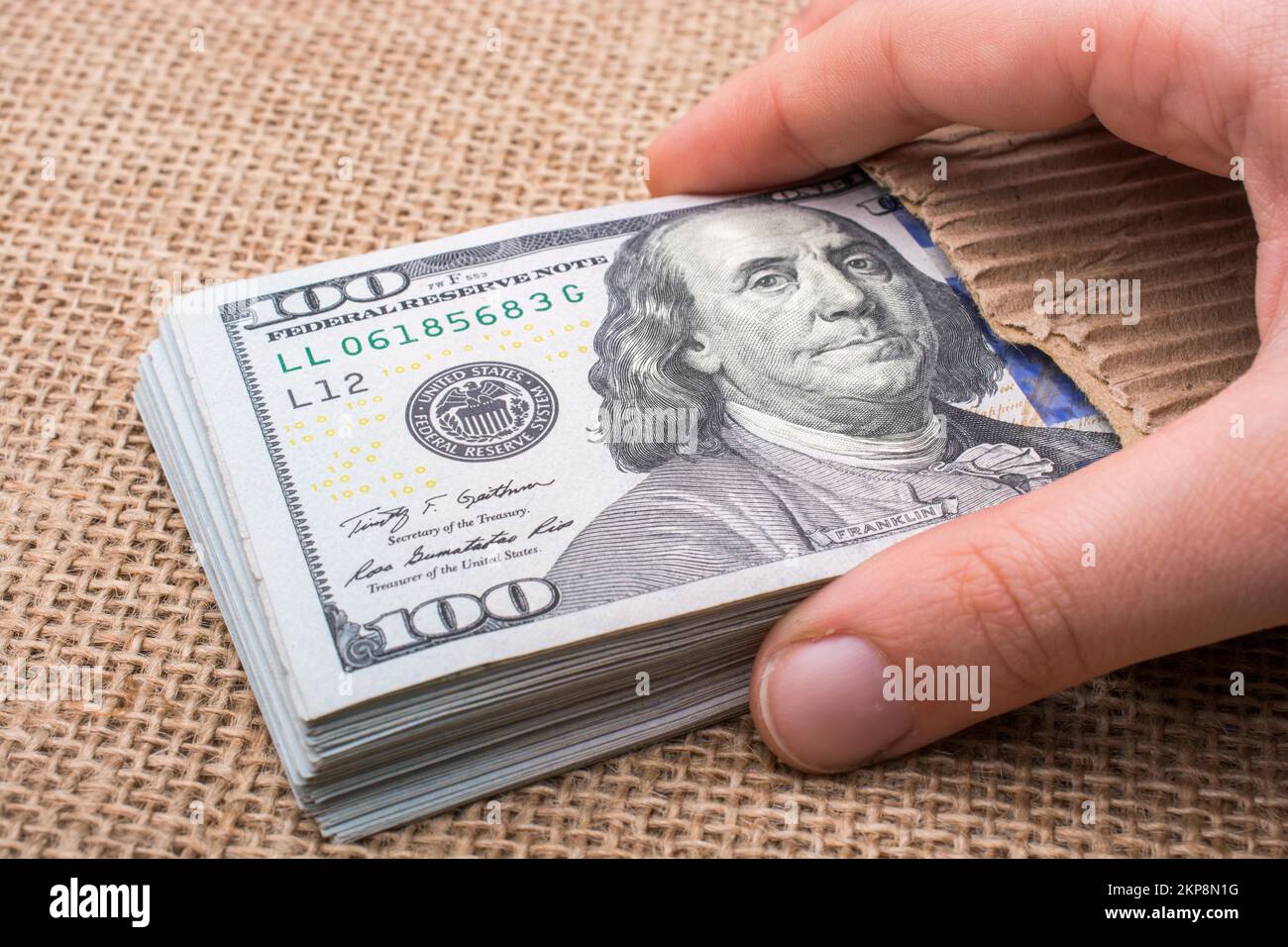 Banknote bundle of US dollar partly wrapped in cardboard Stock Photo ...