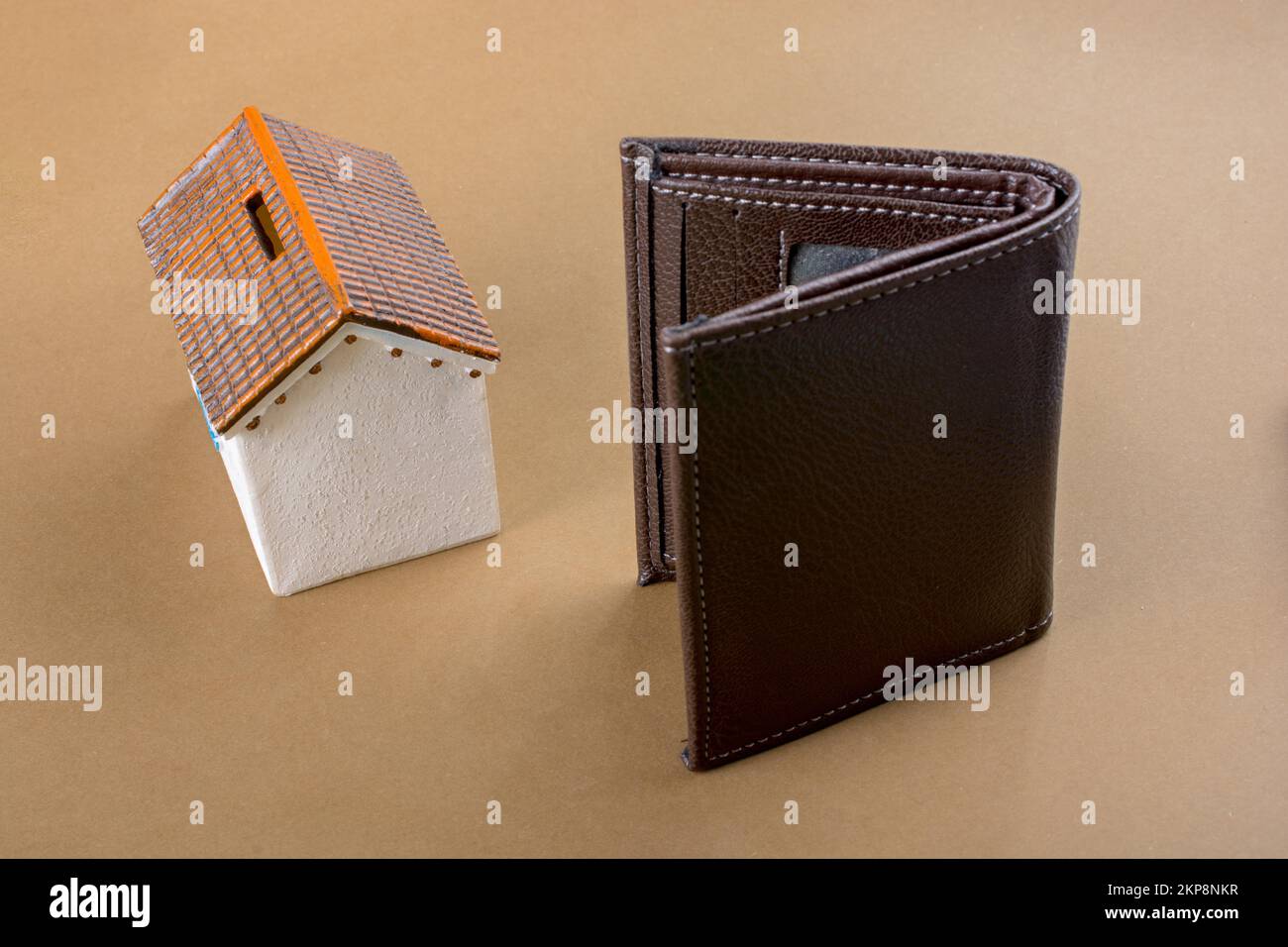 Little model house beside a wallet in view Stock Photo - Alamy