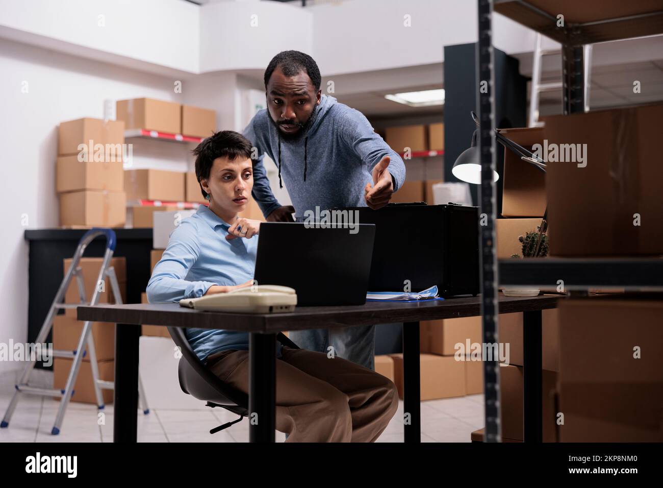 Storehouse employees analyzing metallic box order checking distribution ...