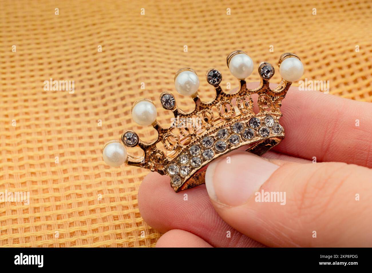Hand holding a little model crown in hand Stock Photo - Alamy