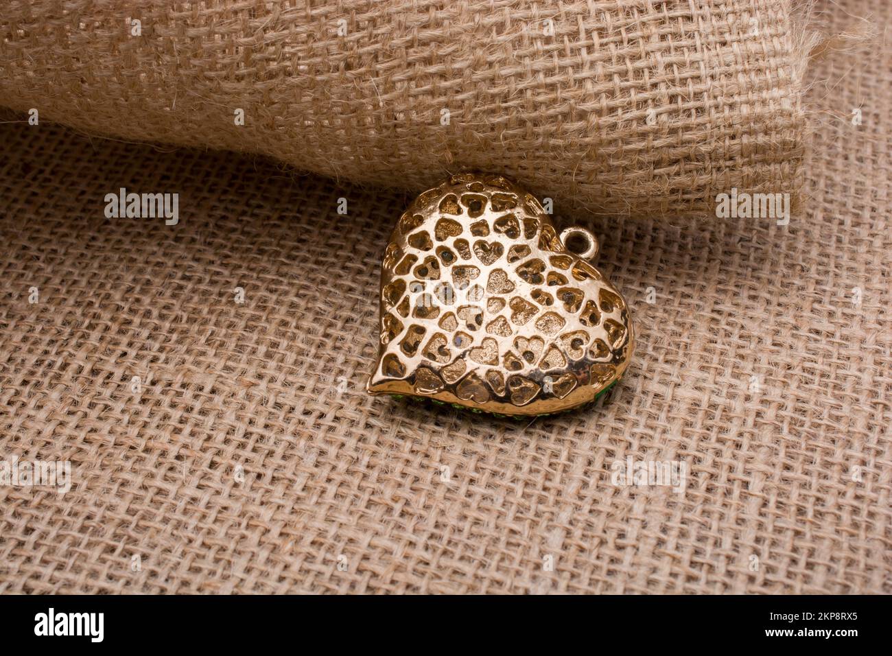 Heart shaped gold color metal object on canvas Stock Photo - Alamy