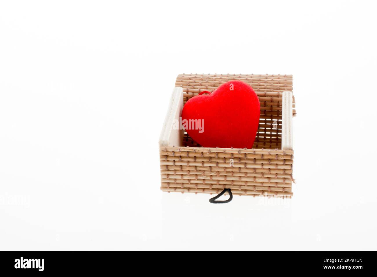 Red heart shaped object placed in a straw box on white background Stock ...