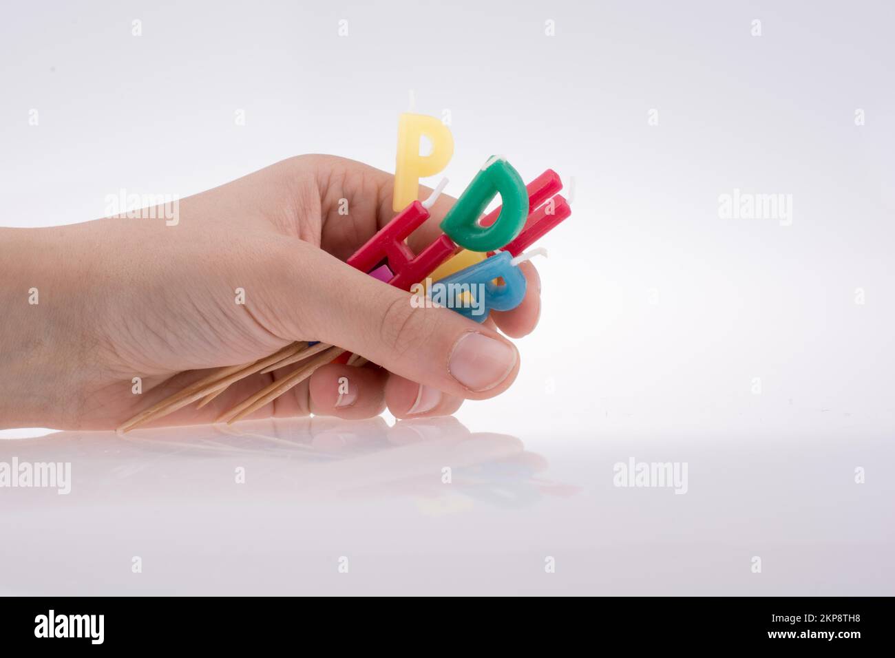 Hand holding letters made of candles on sticks Stock Photo - Alamy