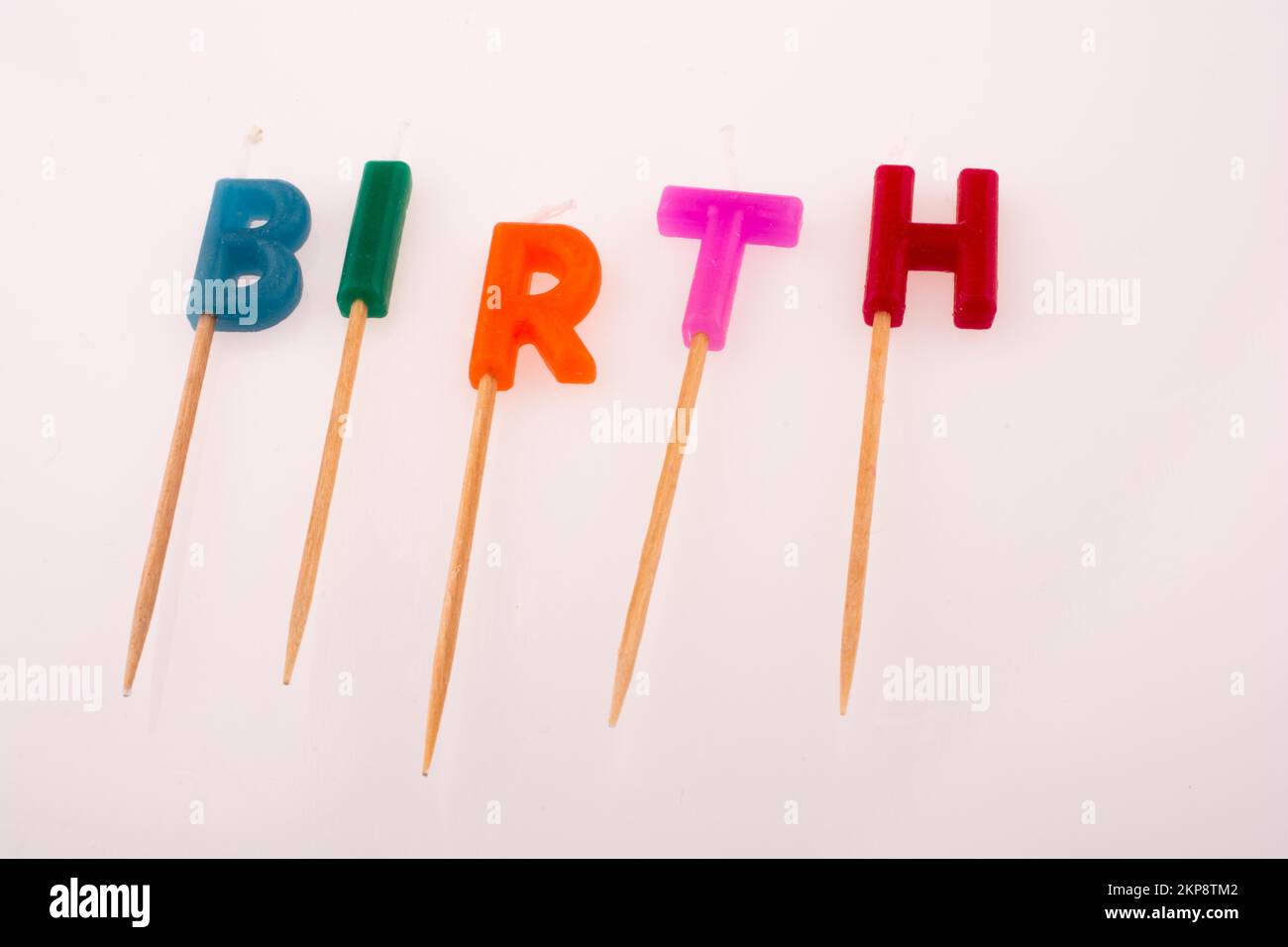 Birth written color candles on a white background Stock Photo - Alamy