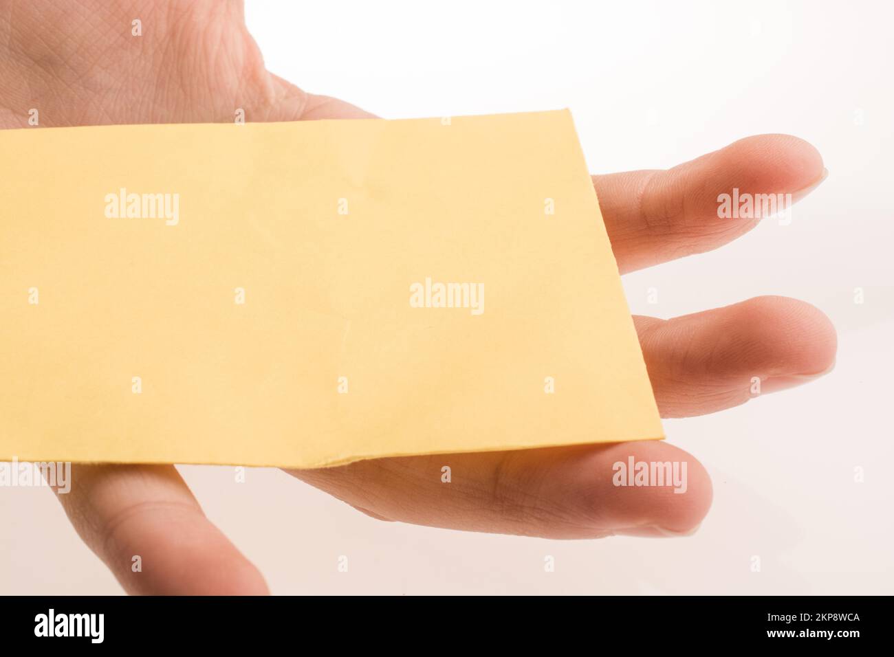 Hand holding yellow color rectangular paper on a white background Stock ...