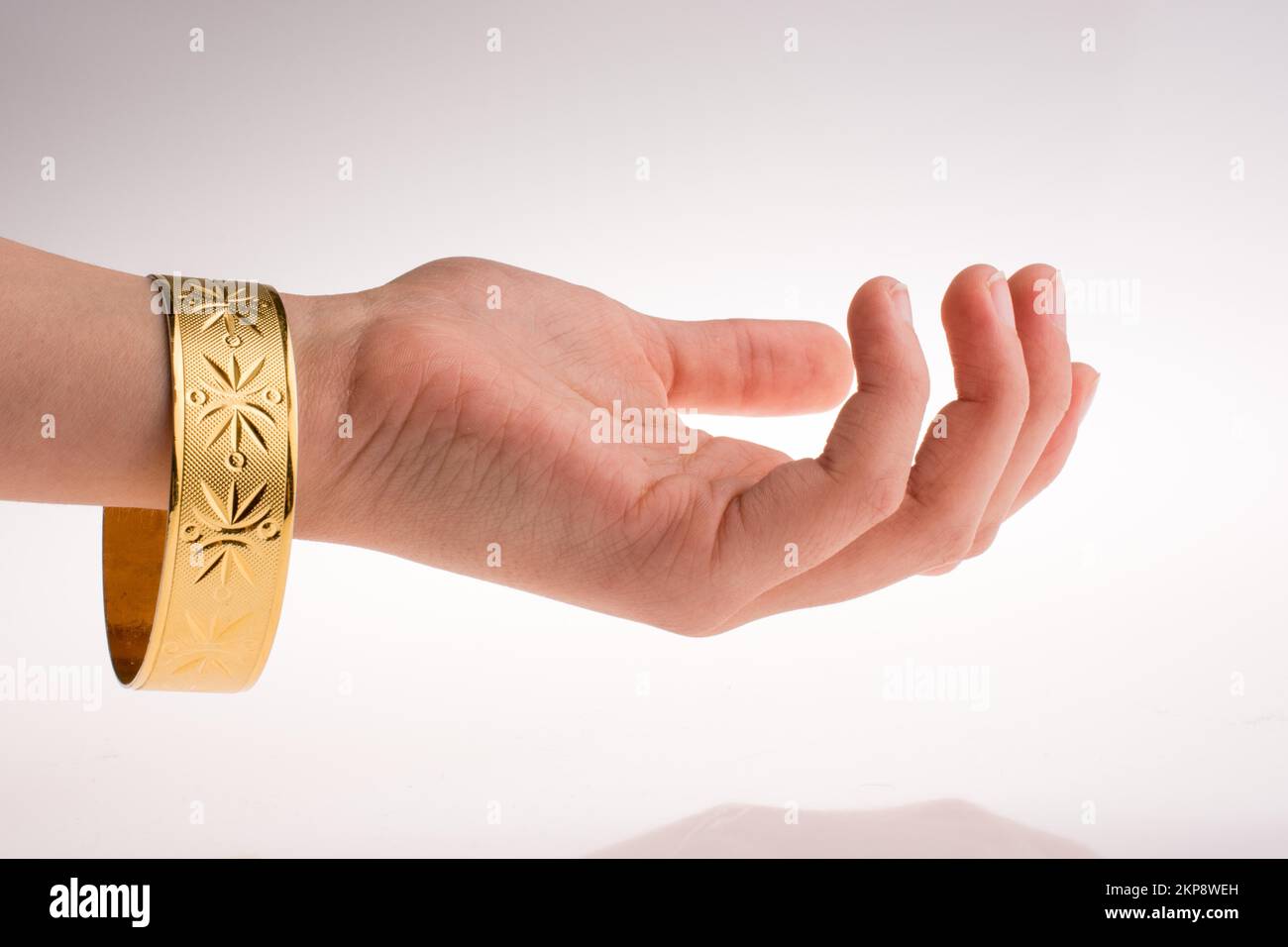Hand with a golden bracelet on a white background Stock Photo - Alamy