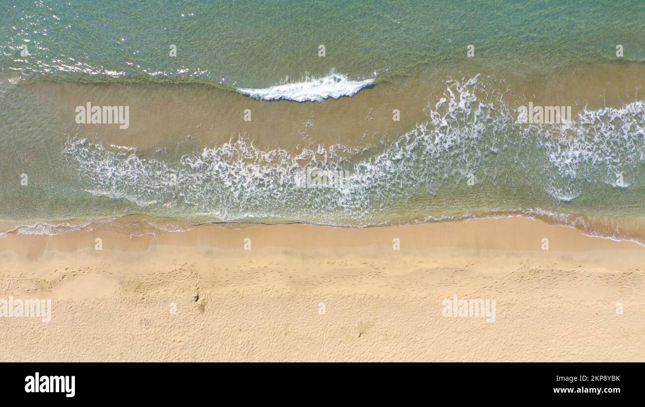 Aerial view of transparent ocean waves washing sandy beach. Slow motion ...