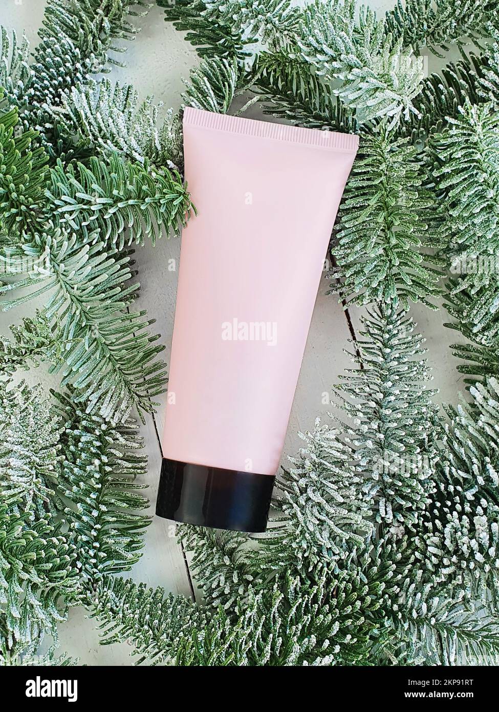 Mockup pink squeeze bottle cosmetic tube with screw black cap and snowy ...