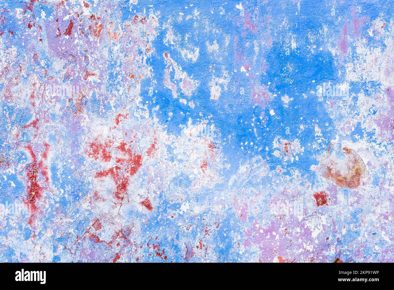 Old painted plaster wall outside, paint in many colours peeling off ...