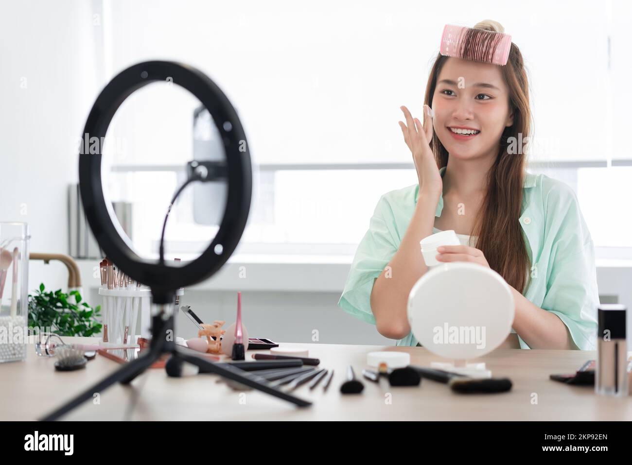 Beauty Vlogger concept, Young woman applying moisturizer cream on face ...