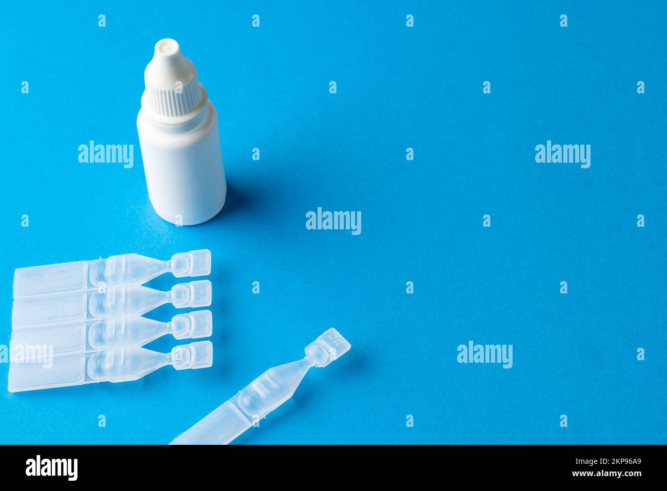 Composition of saline solution caplets and dropper bottle on blue ...