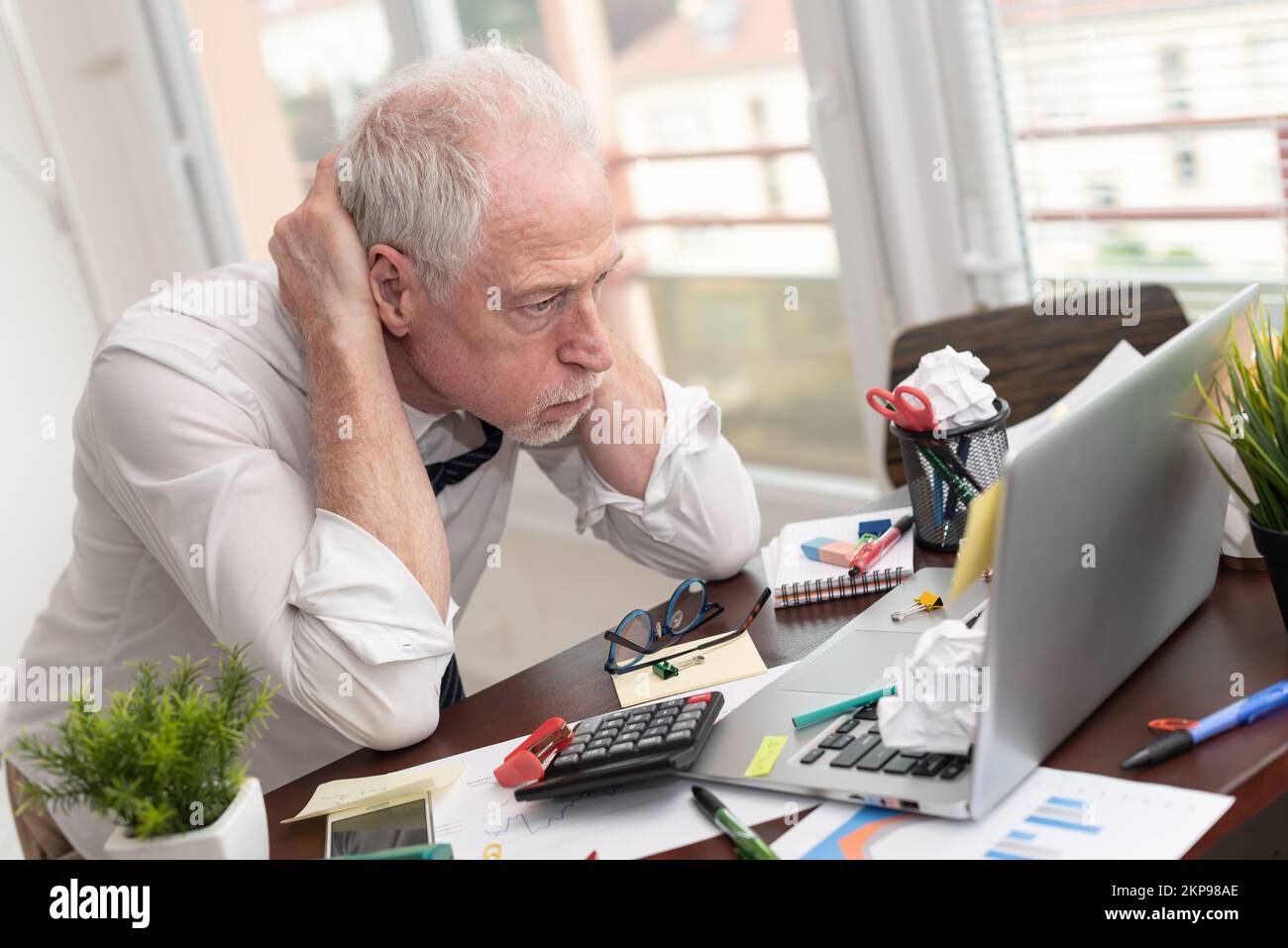 Overworked senior businessman sitting at a messy desk Stock Photo - Alamy