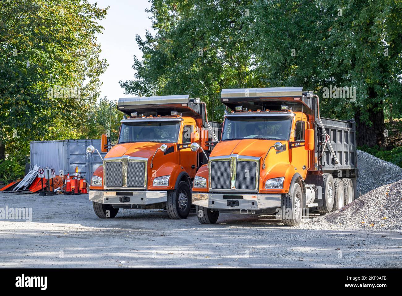 Two powerful heavy duty orange professional tipper trucks standing on ...