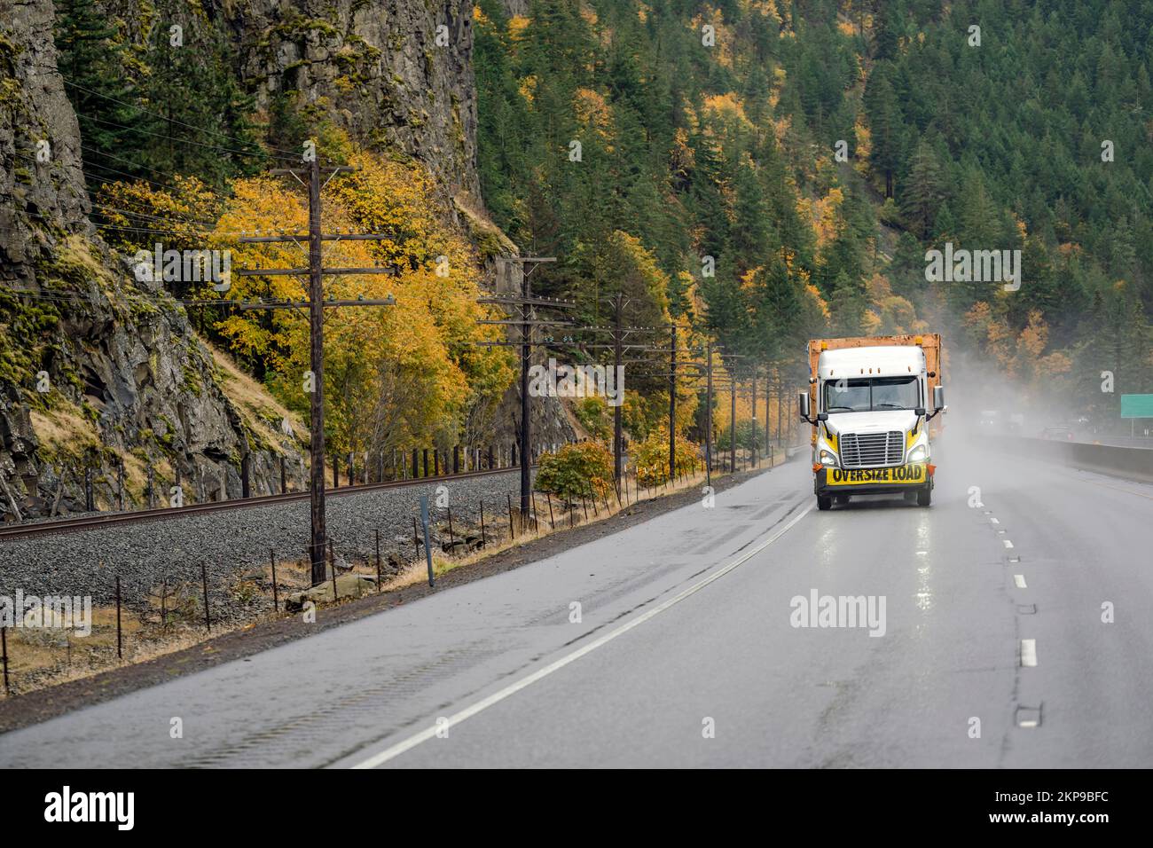 White powerful big rig classic semi truck tractor with oversize load ...