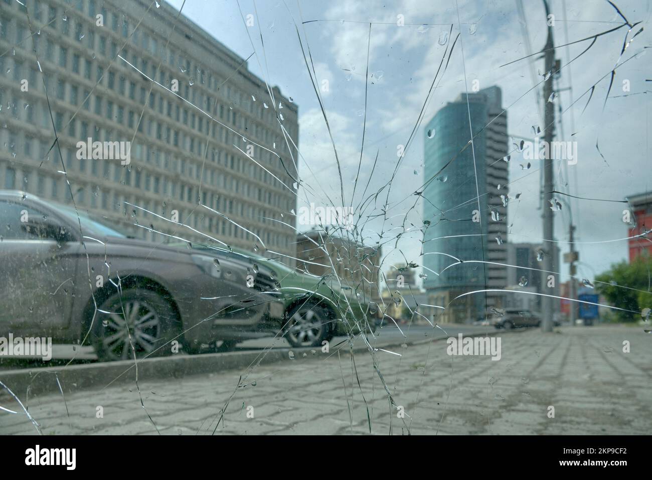View of city and people through cracked glass. City as habitat with ...