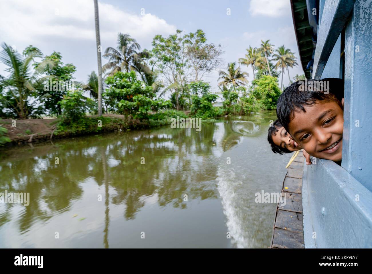 Alleppey, India. 26th Nov, 2022. Children lean out of the window in the ...
