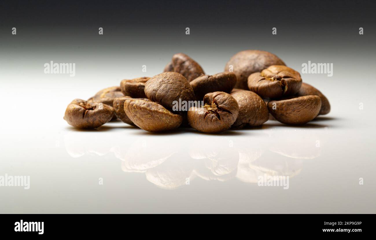 A pile of brown coffee beans on a white table background Stock Photo ...