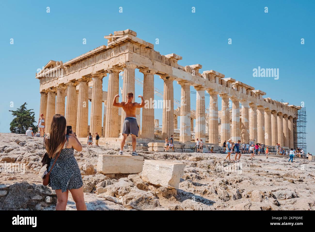 Athens, Greece - August 30, 2022: A visitor man poses for a photo showing muscle in front of the ...