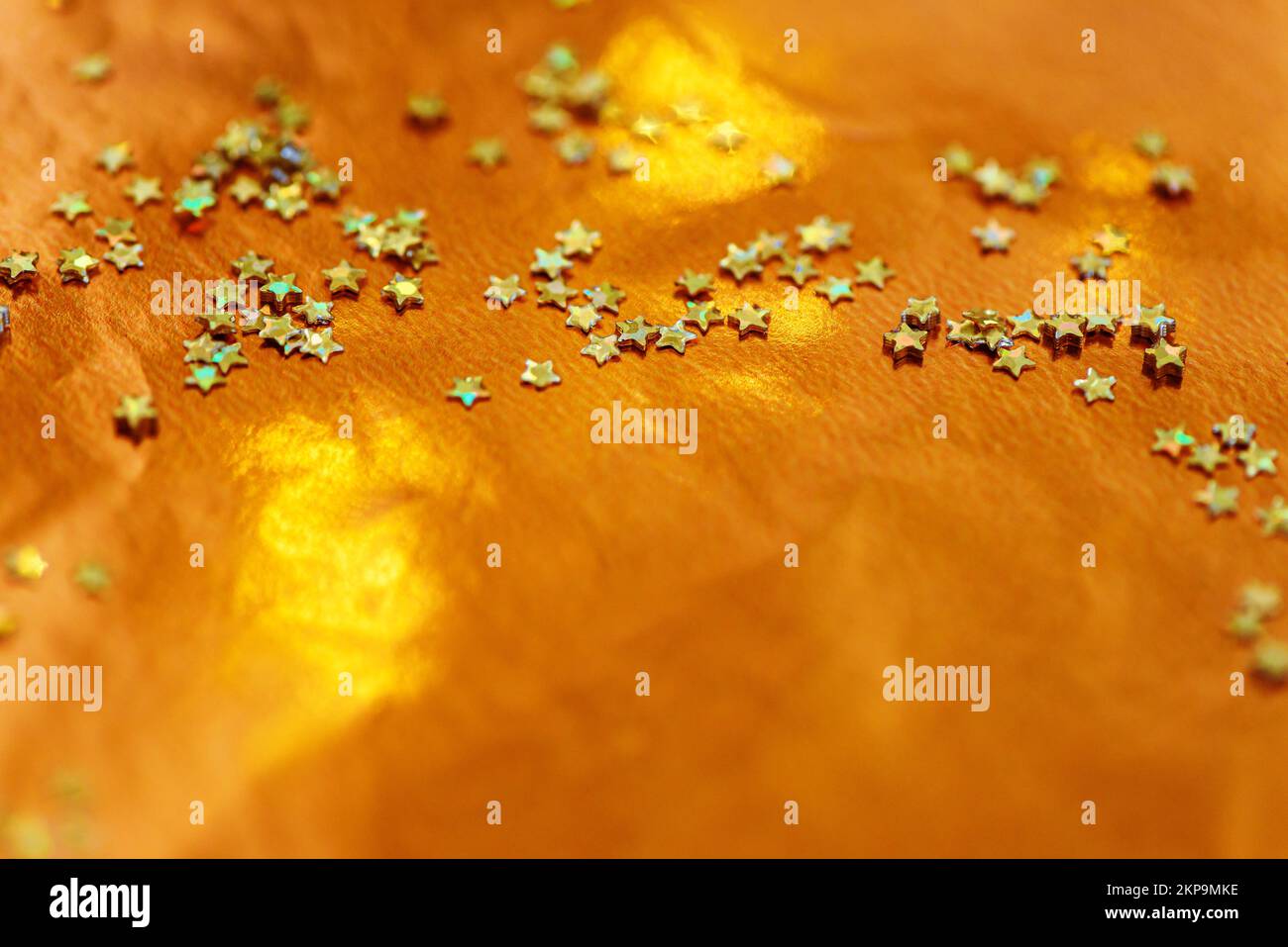 Tiny sparkling stars scattered on golden paper background Stock Photo ...