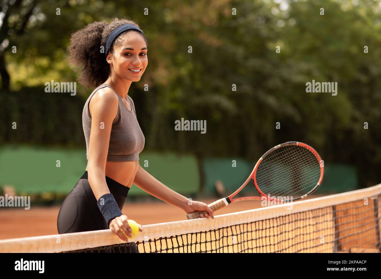 Cute dark-haired girl having a workout at the tennis court Stock Photo ...