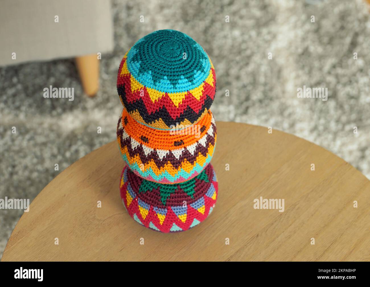Close up of three colorful crocheted juggling balls on a round table ...