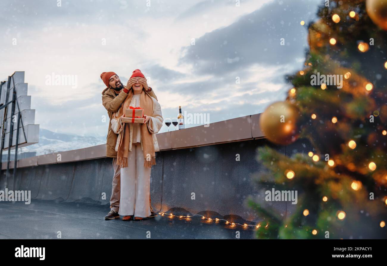 Happy family are celebrating Christmas outdoors. Two young people are ...