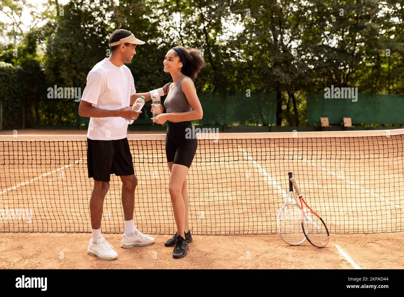 Young tennis players talking after the game Stock Photo - Alamy