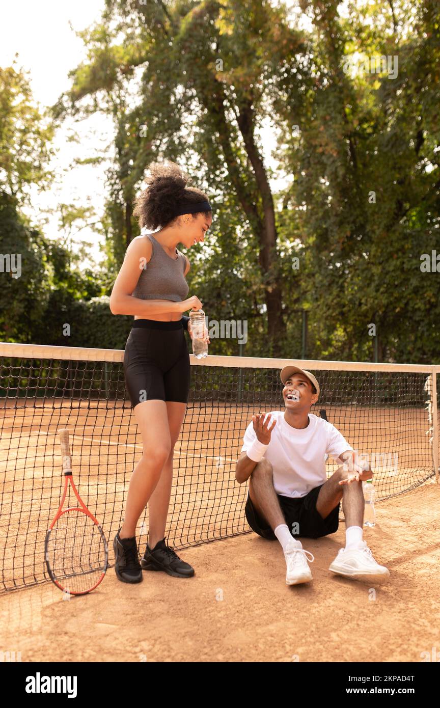 Young tennis players talking after the game Stock Photo - Alamy