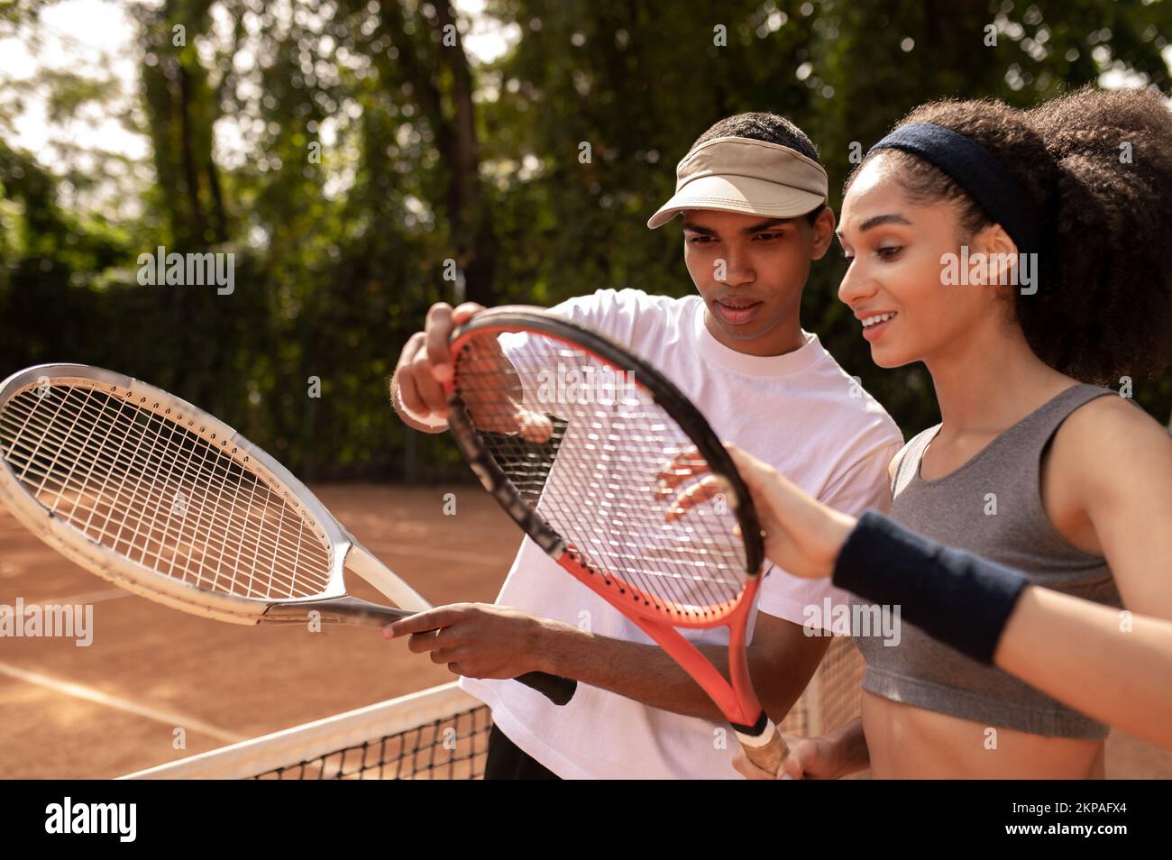 Male coach showing the girl how to hold the tennis racket Stock Photo ...